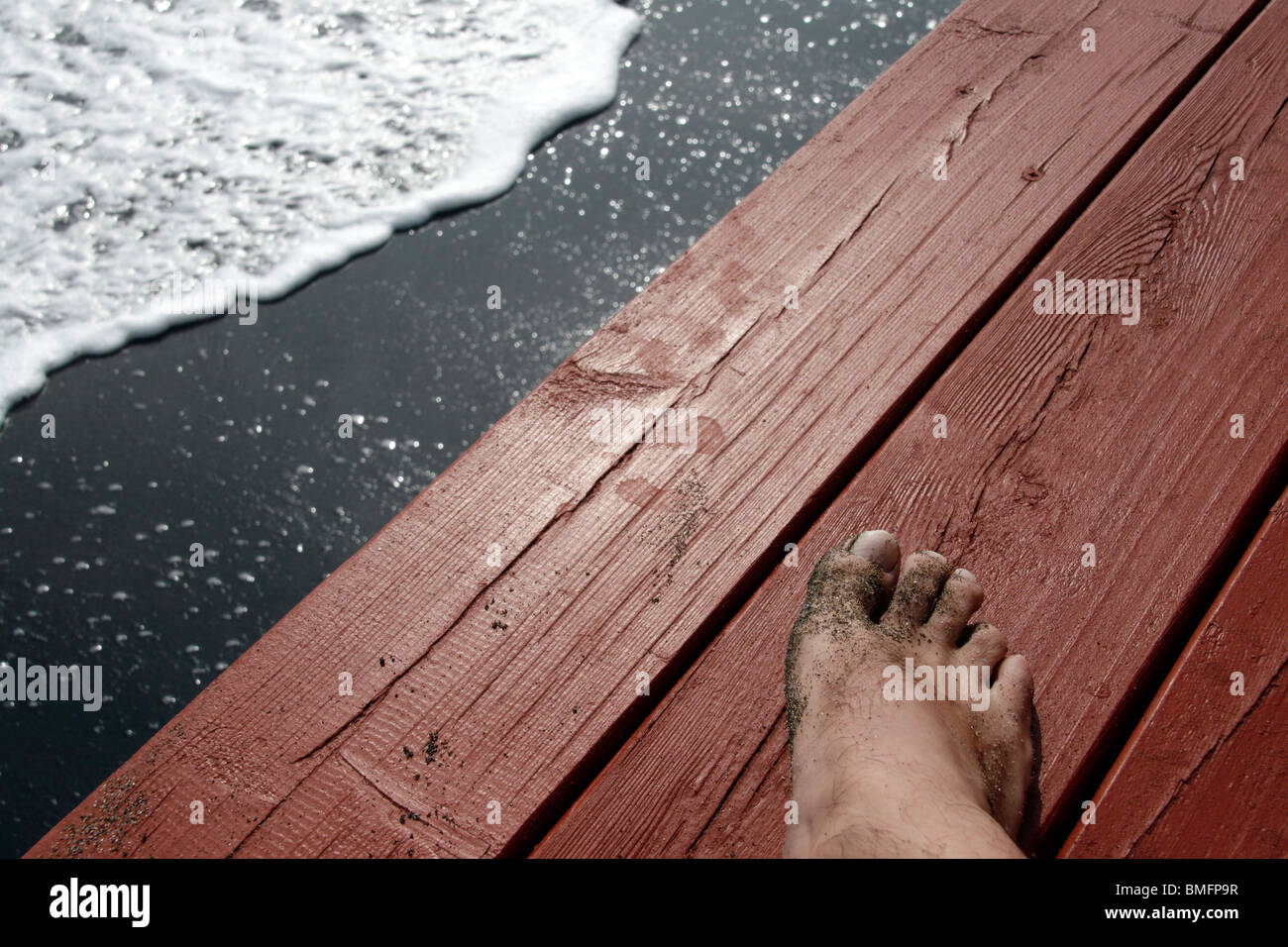 man standing on red jetty by waves in sea Stock Photo - Alamy