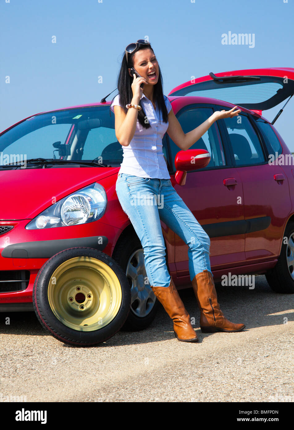 Young woman with a tire breakdown at car Stock Photo - Alamy