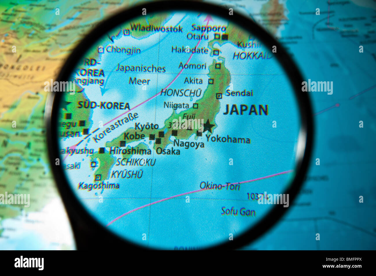 Japan viewed on a globe with the magnifying glass Stock Photo - Alamy
