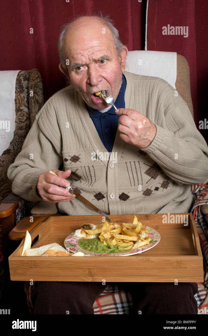 Elderly man eating fish and chips while watching TV Stock Photo - Alamy