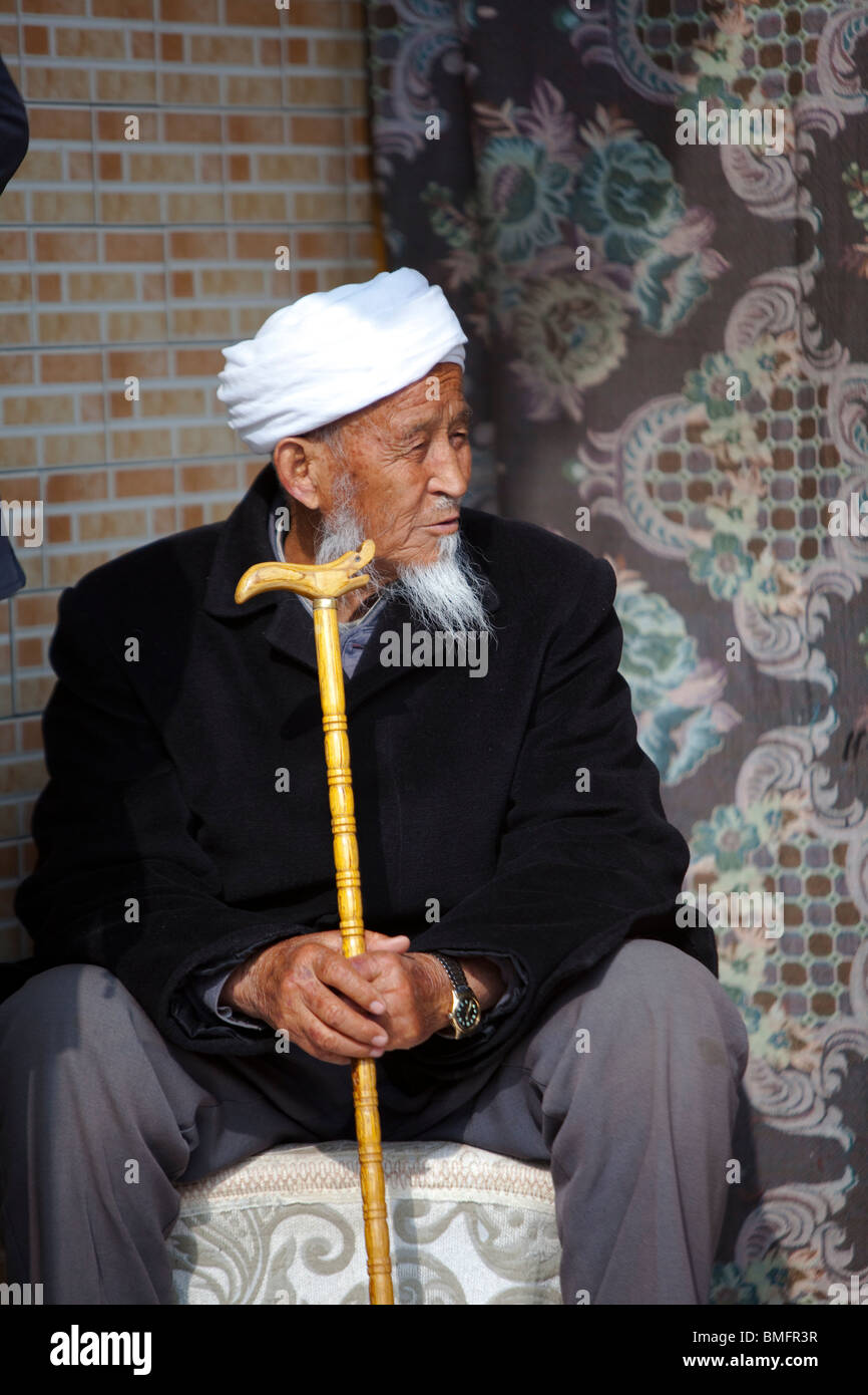 Elderly Salar man with a walking stick, Xunhua Salar Autonomous County ...