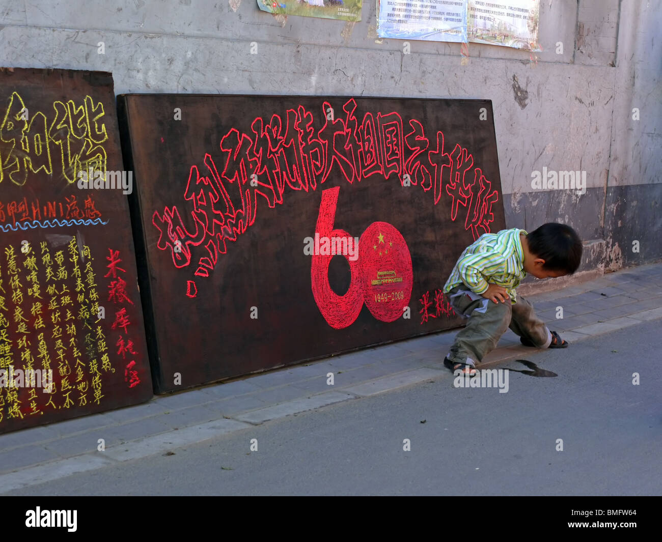 Little boy pissing near the holiday banner dedicated to the 60th ...