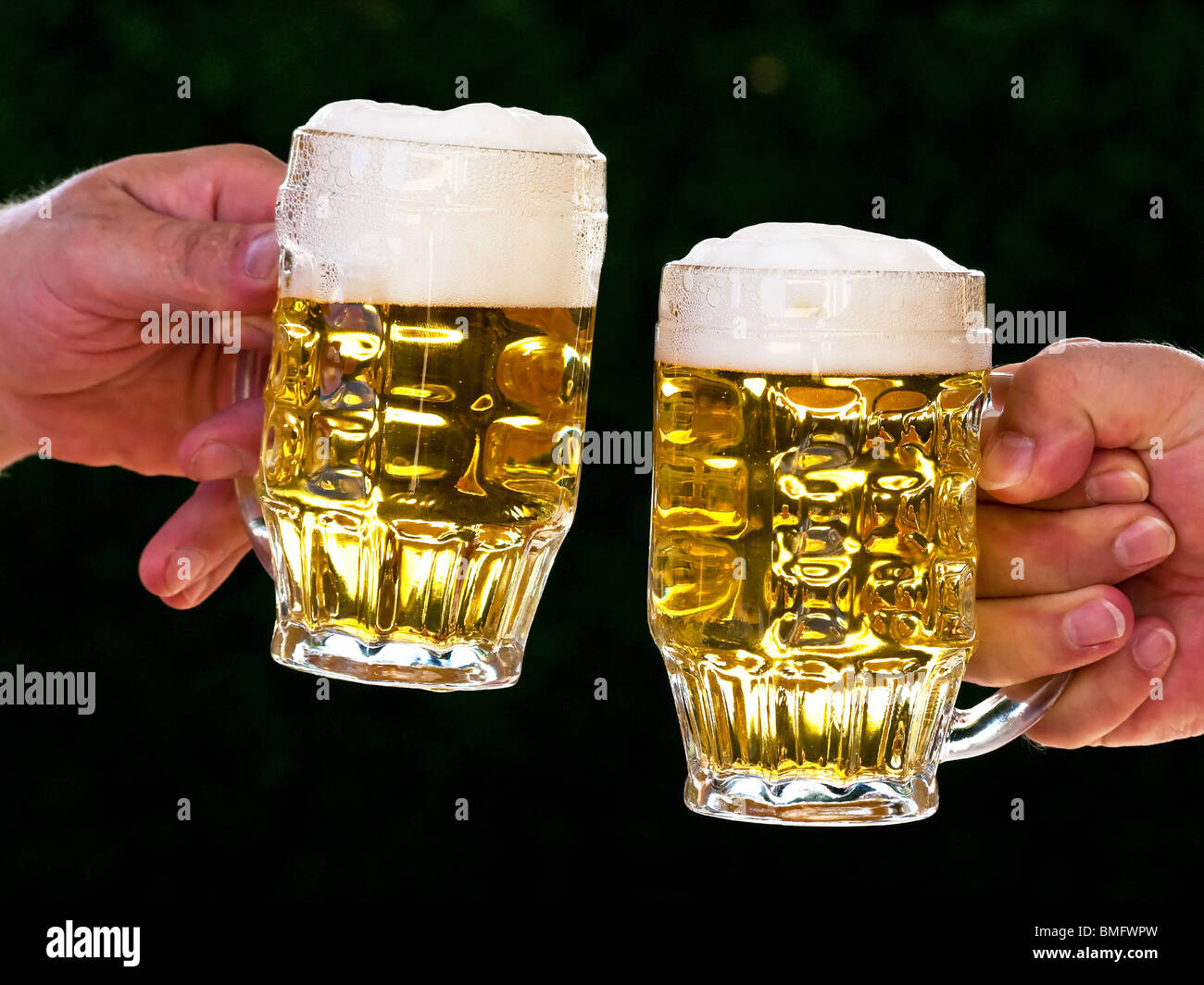 Two pitchers of beer and beer foam toasting Stock Photo - Alamy