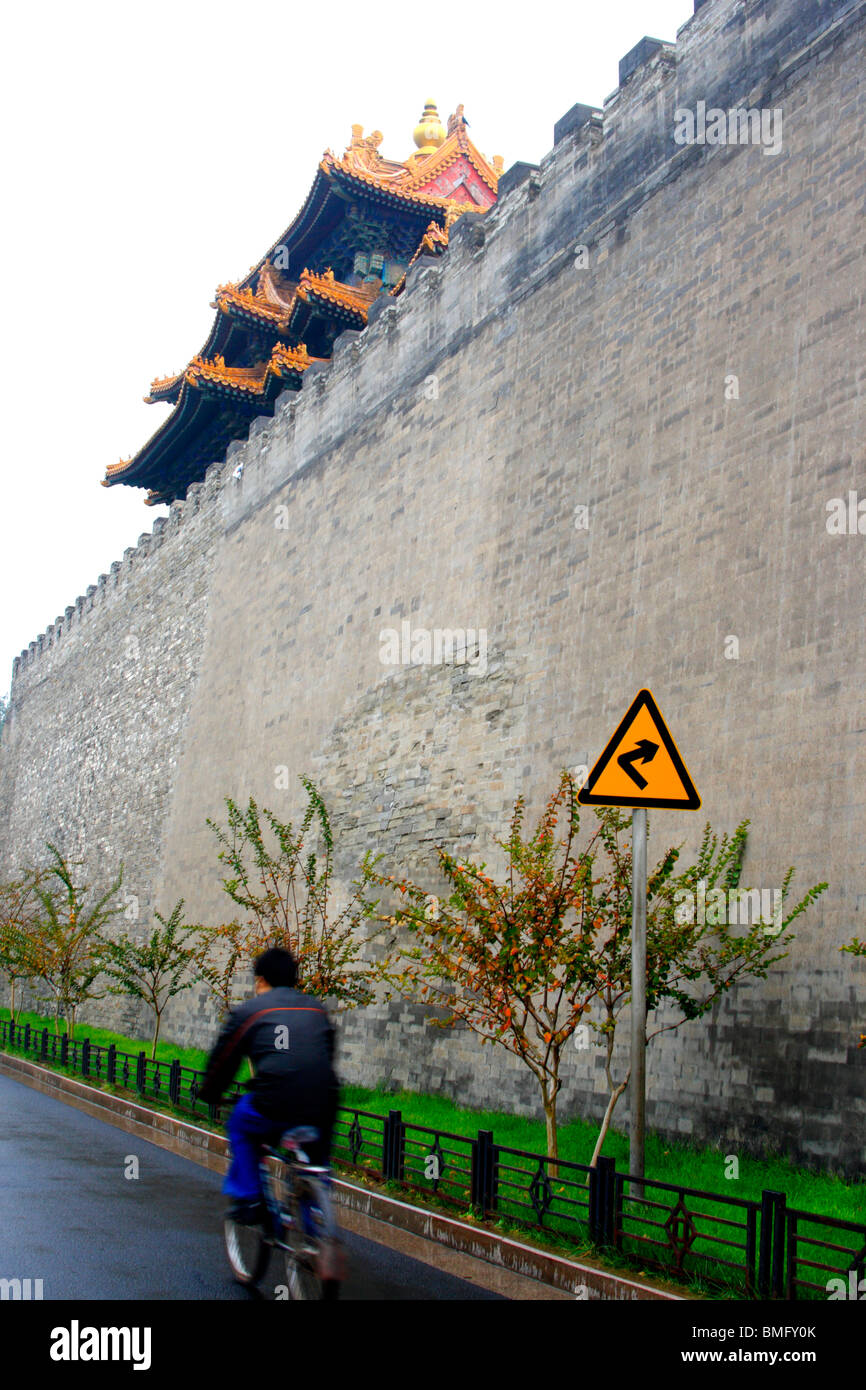 Chinese man riding bicycle along palace wall and Corner Tower of ...