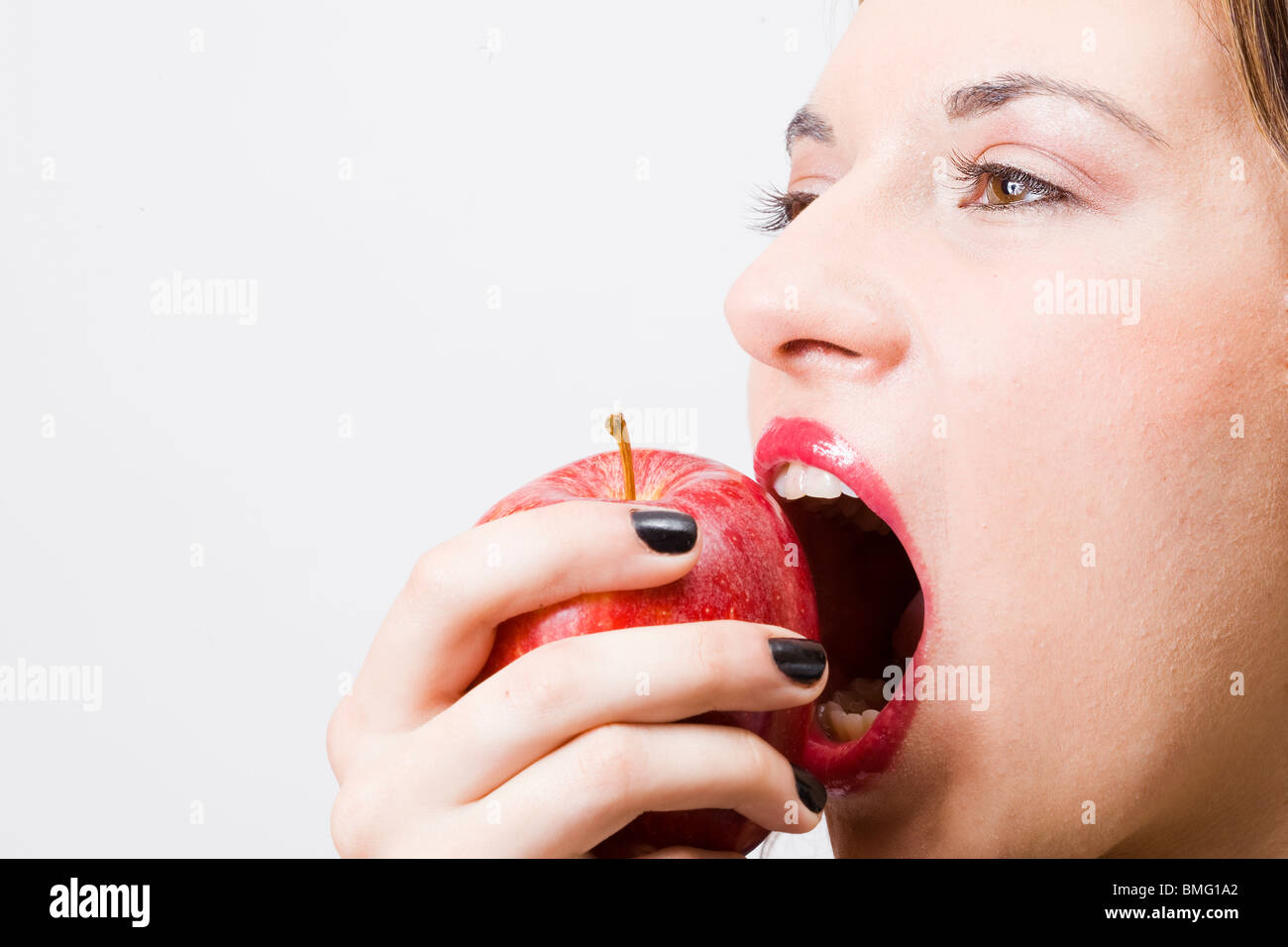 a young pretty girl eating a fresh healthy red apple Stock Photo - Alamy