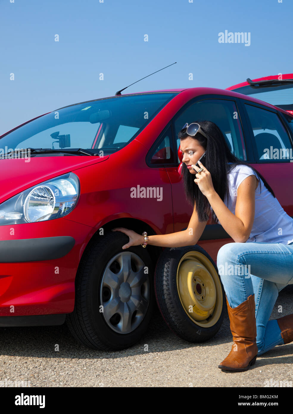 Young woman with a tire breakdown at car Stock Photo - Alamy
