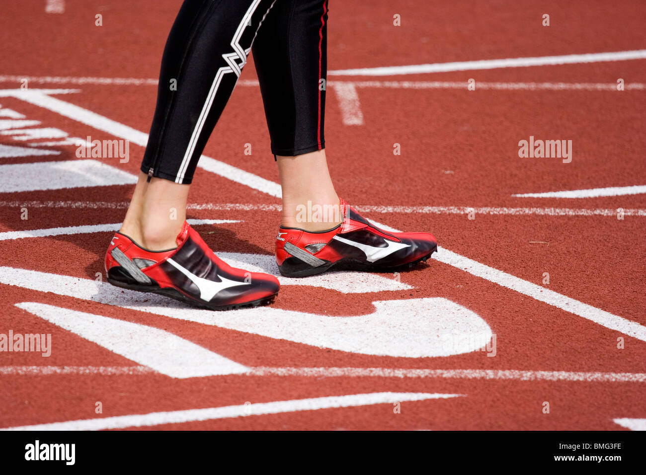 Athletes at the start on red running track Stock Photo - Alamy