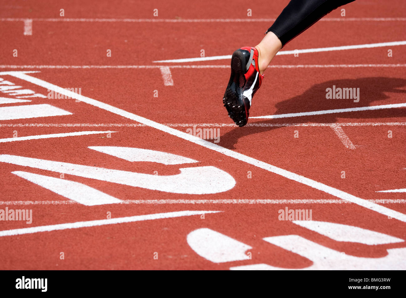 Athletes at the start on red running track Stock Photo - Alamy