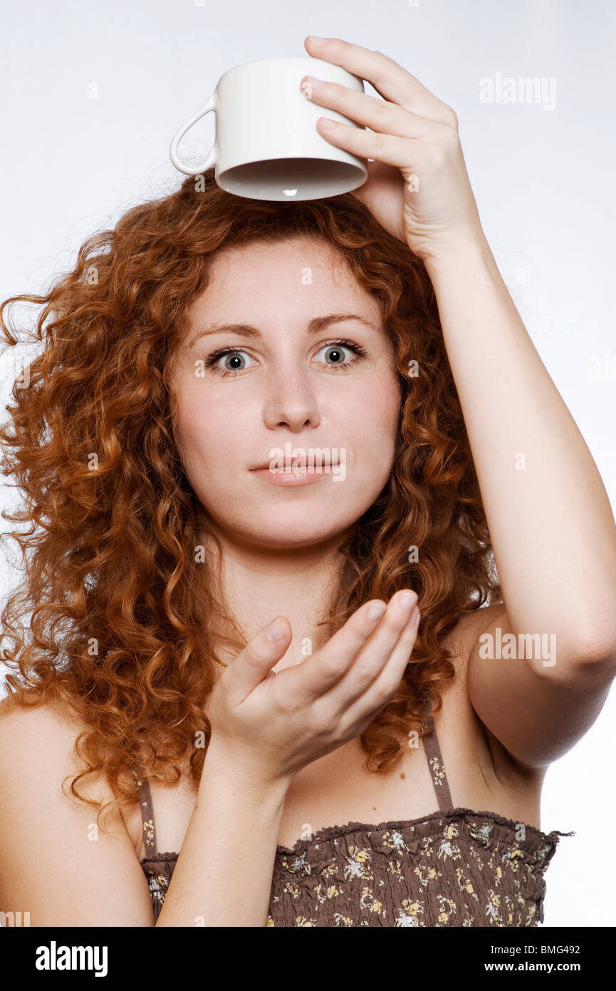Woman holding cup upside down above head Stock Photo - Alamy
