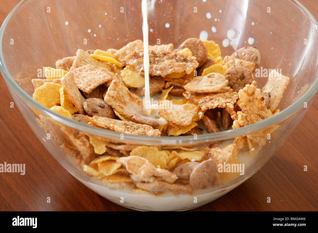 Milk pouring onto corn flakes bowl Stock Photo - Alamy