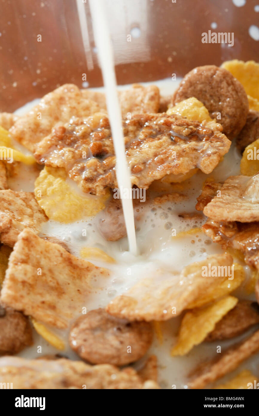 Milk pouring onto corn flakes bowl Stock Photo - Alamy