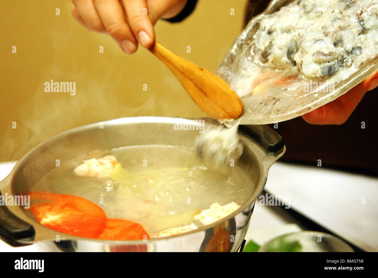 Waitress sliding shrimp paste into hot pot, Yuetang Restaurant, Beijing ...