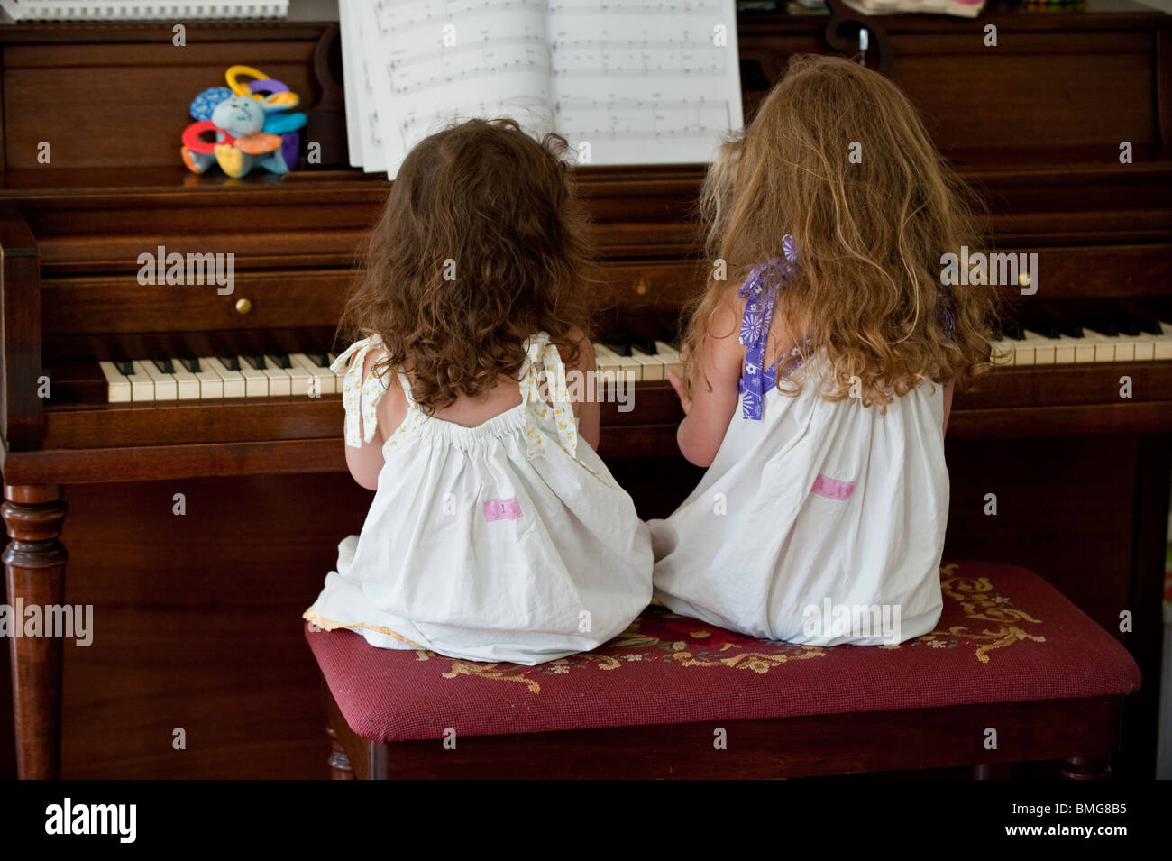 Two young sisters playing piano together Stock Photo - Alamy