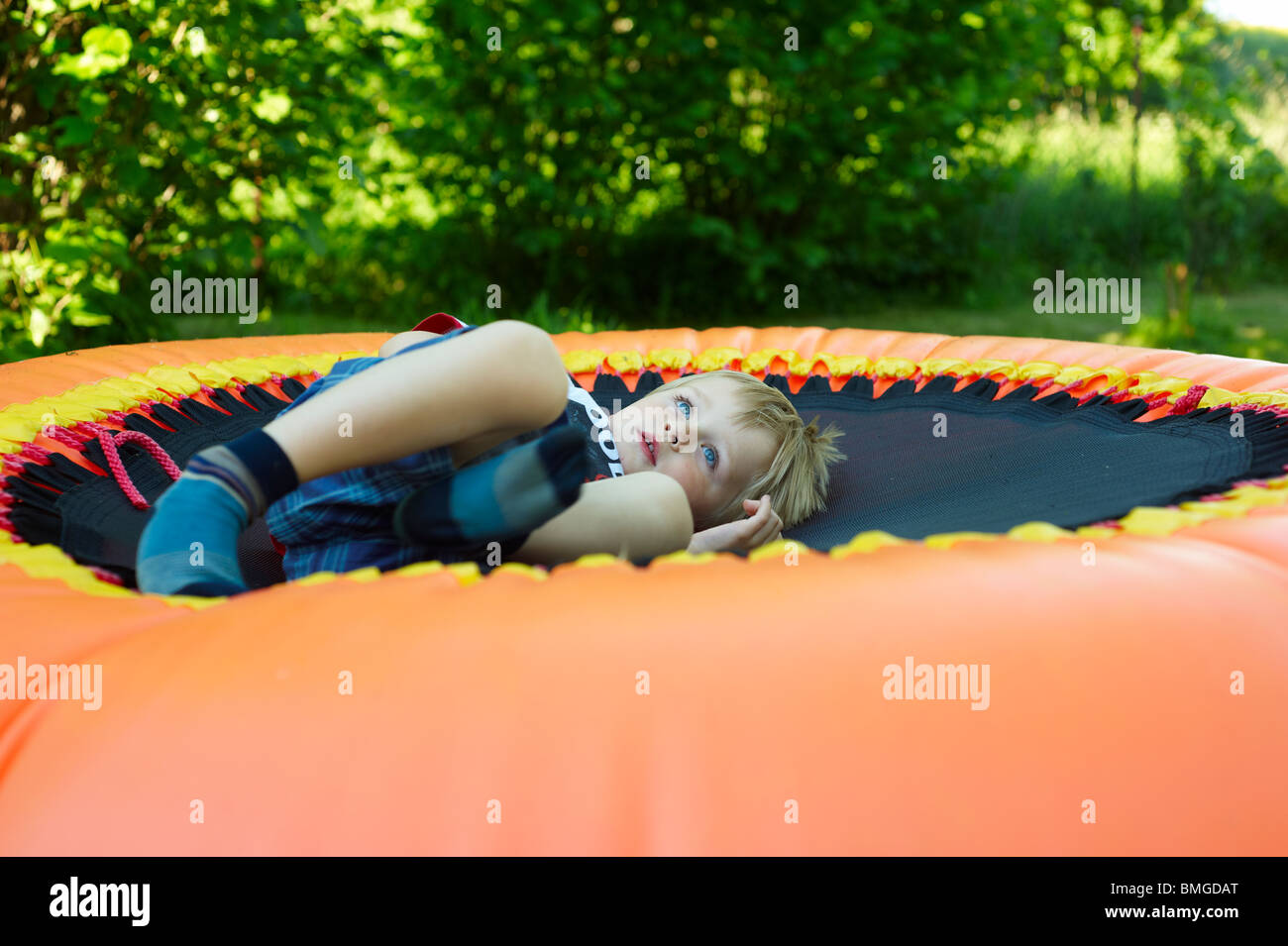 Blond Child Boy Jumping on orange Trampoline in Yard summer Stock Photo ...