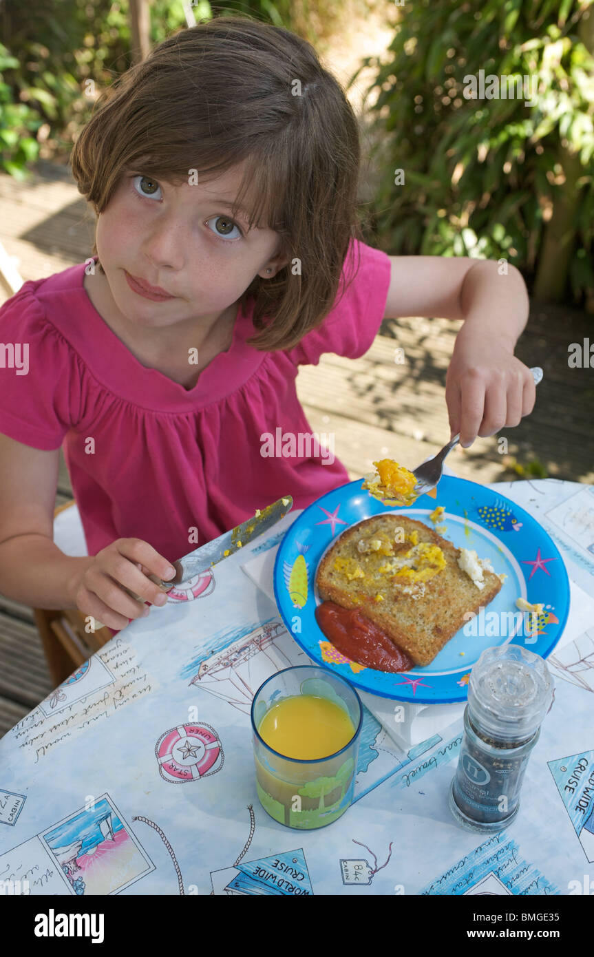 Young girl eating breakfast outside in the garden Stock Photo - Alamy