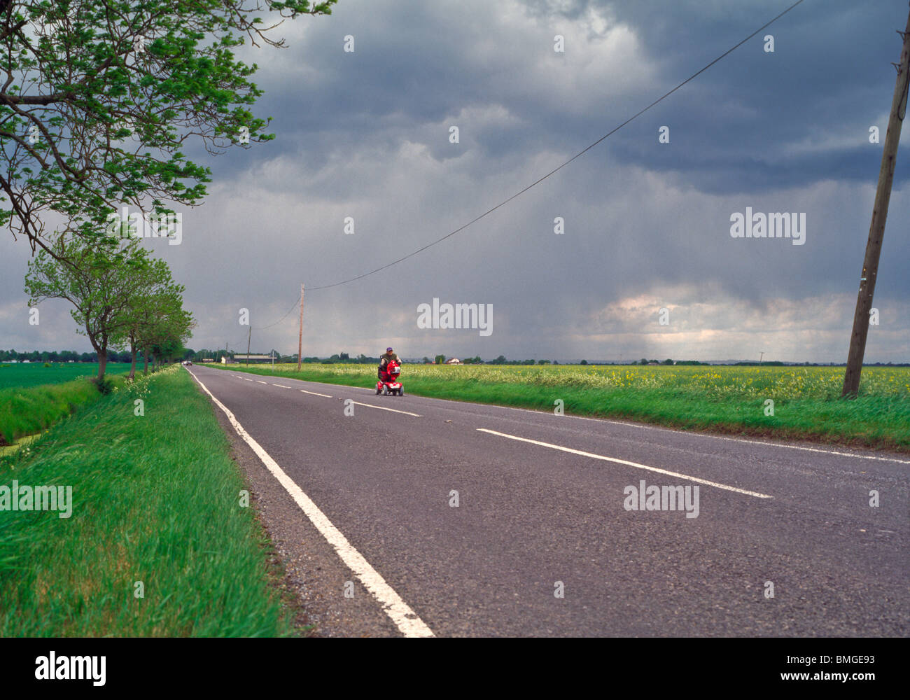 Mobility scooter and driver on open road Stock Photo - Alamy