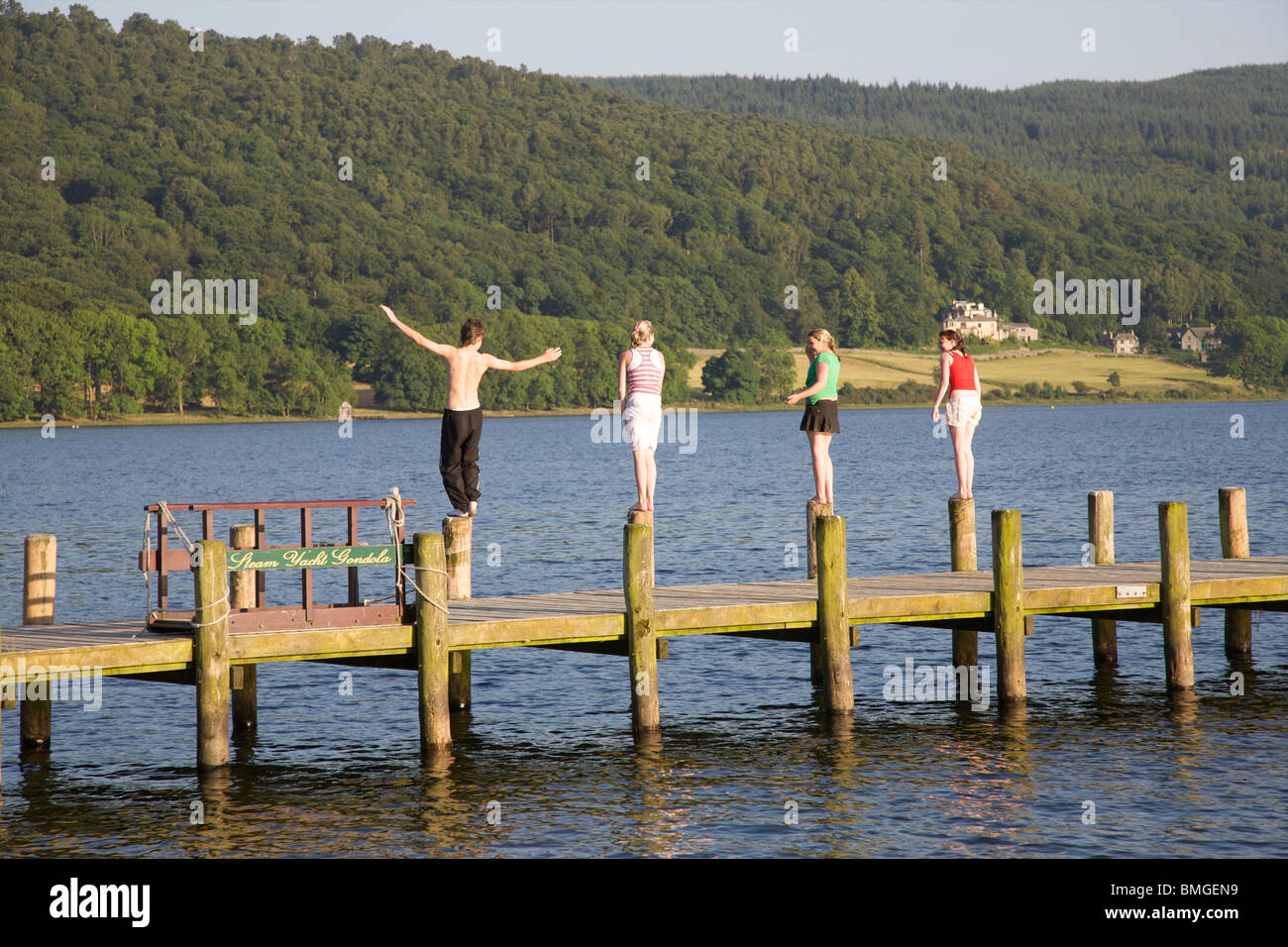 Young people diving into Coniston Water in the Lake District in Cumbria ...