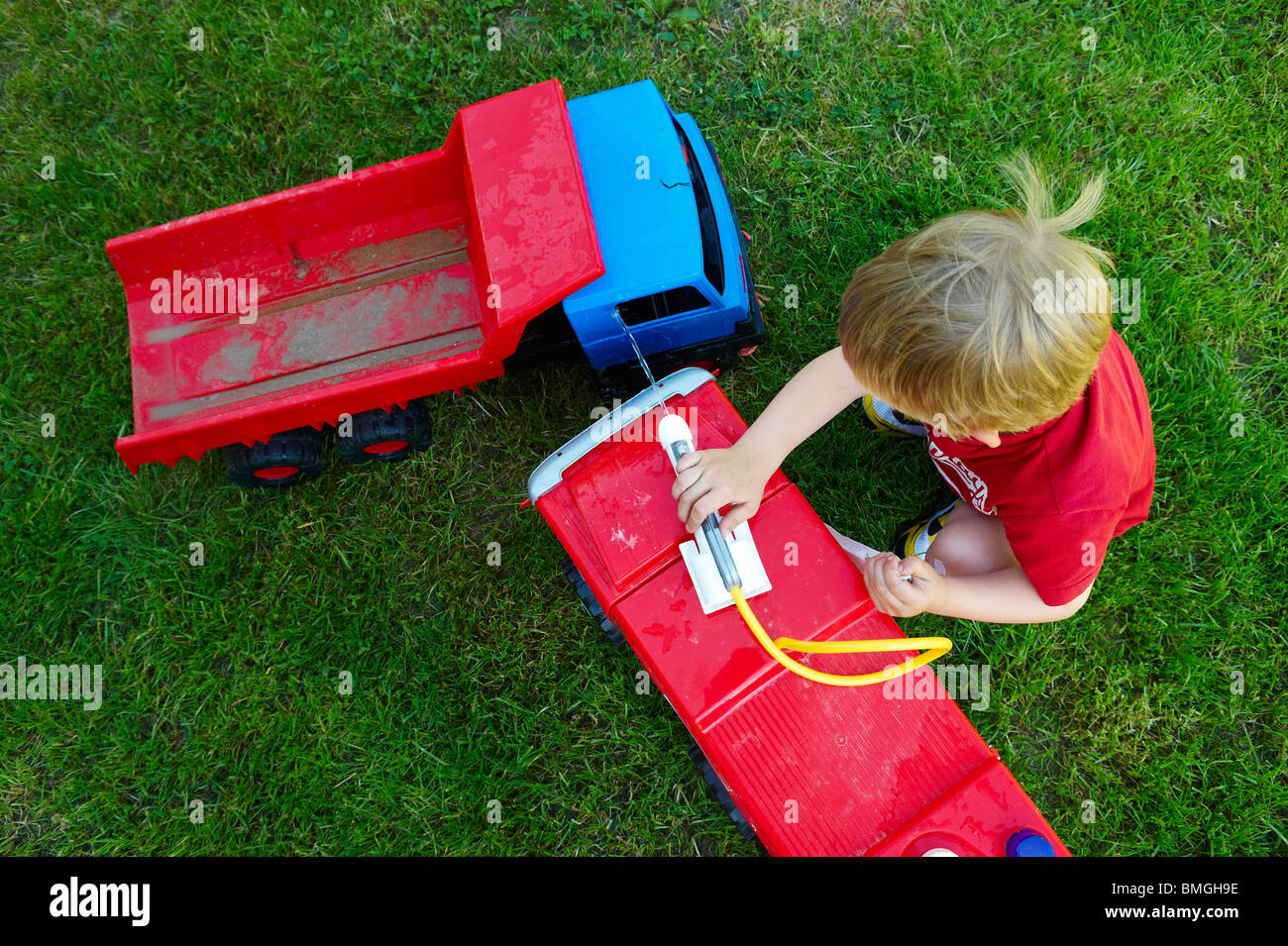 Boy With Toy Fire Engine on garden lawn Stock Photo - Alamy
