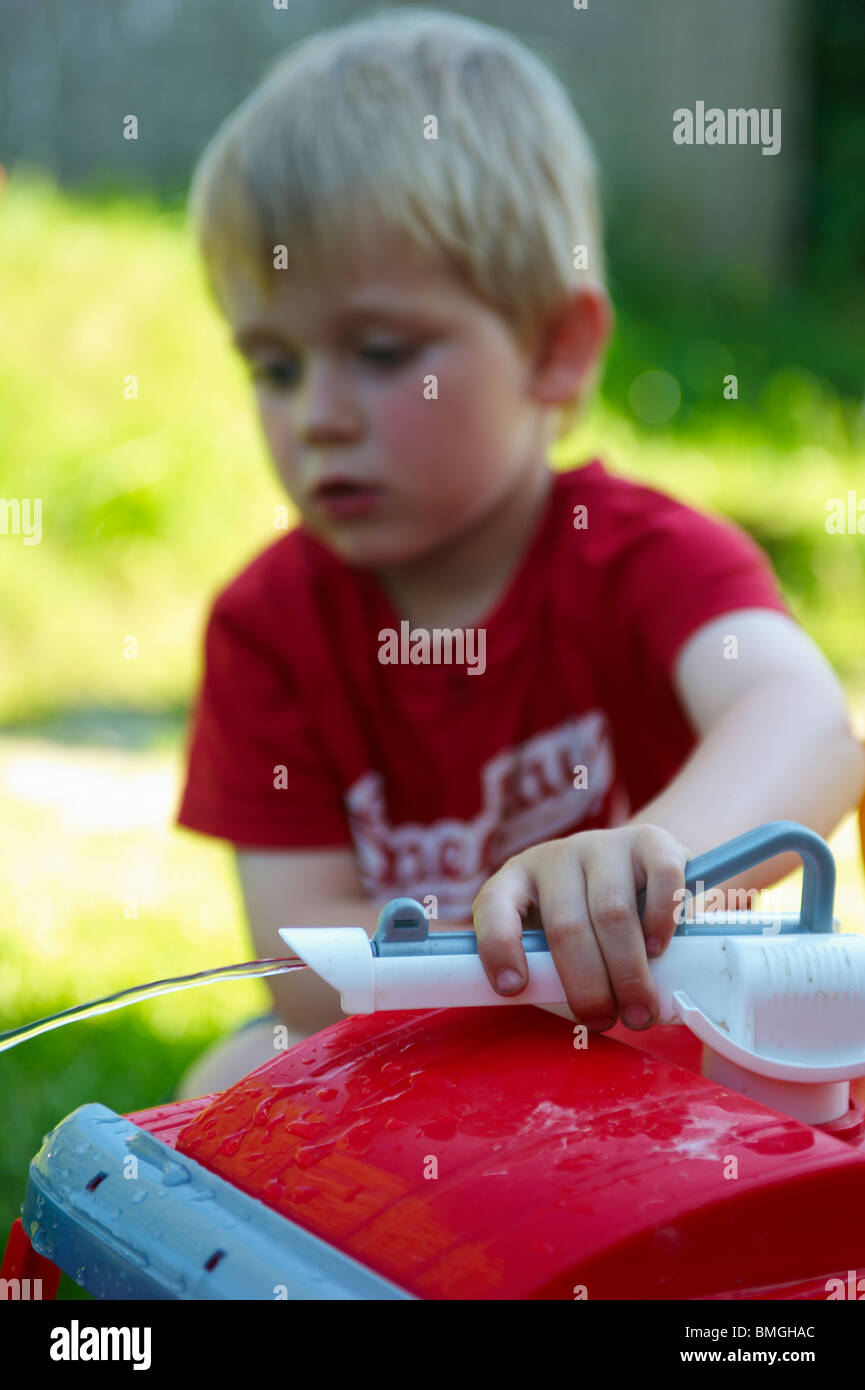 Boy With Toy Fire Engine on garden lawn Stock Photo - Alamy