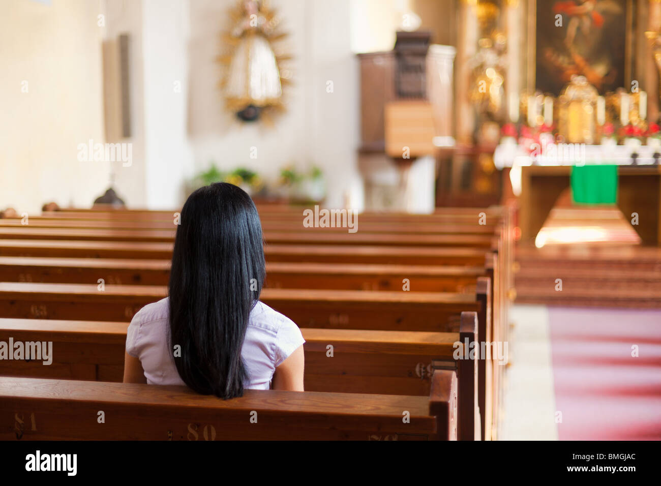 Young woman prays in a church Stock Photo - Alamy
