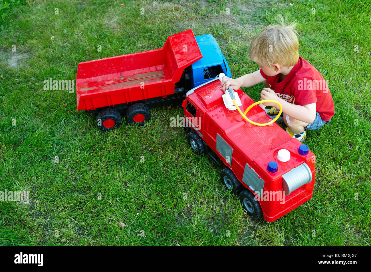 Boy With Toy Fire Engine on garden lawn Stock Photo - Alamy