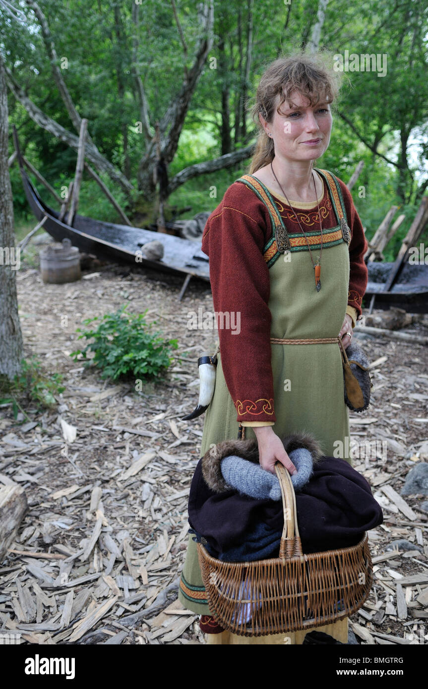 Woman in viking costume carrying a basket in viking town Birka on ...