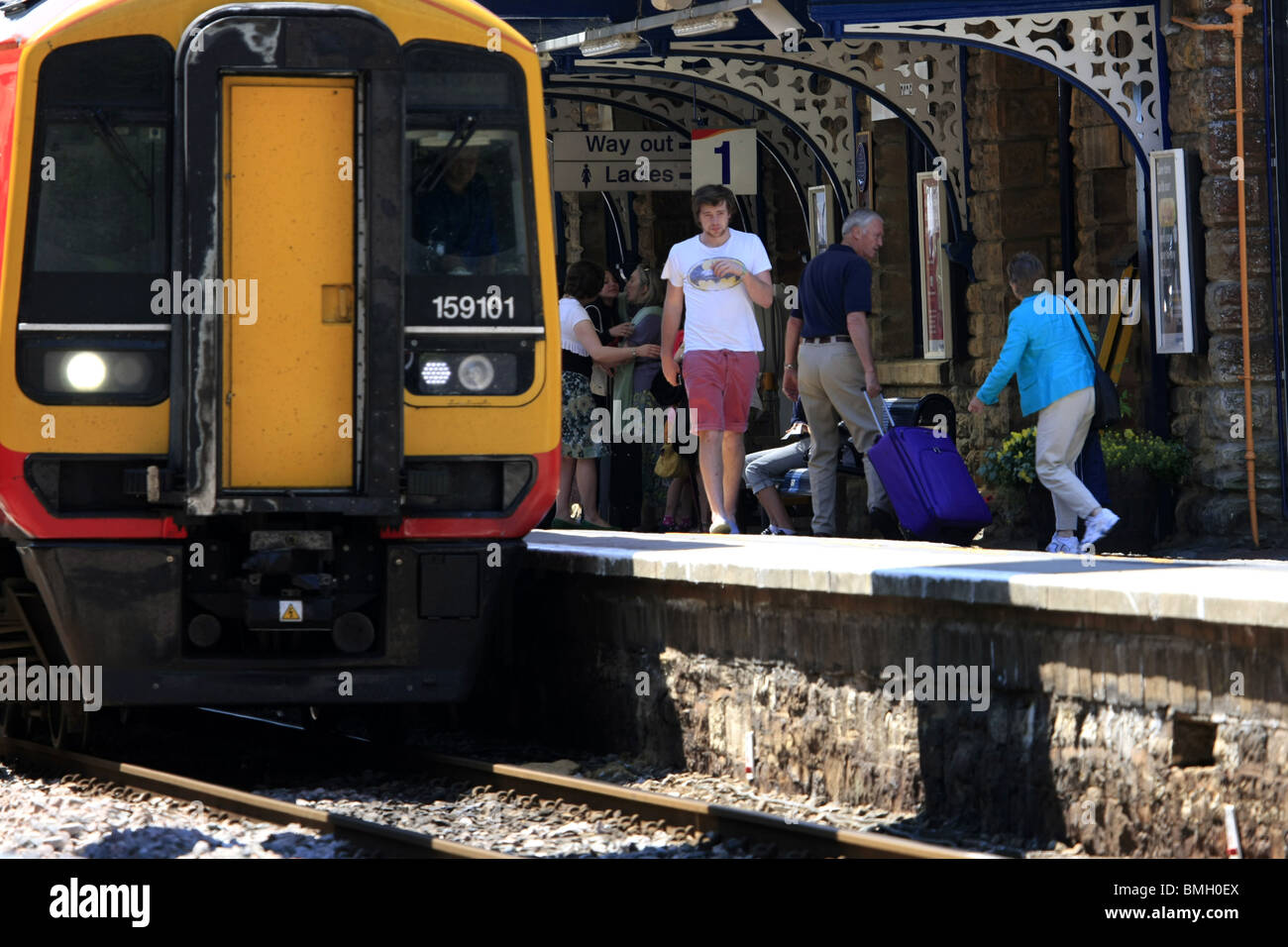 Diesel Train at a station with people gathering their belongings to ...