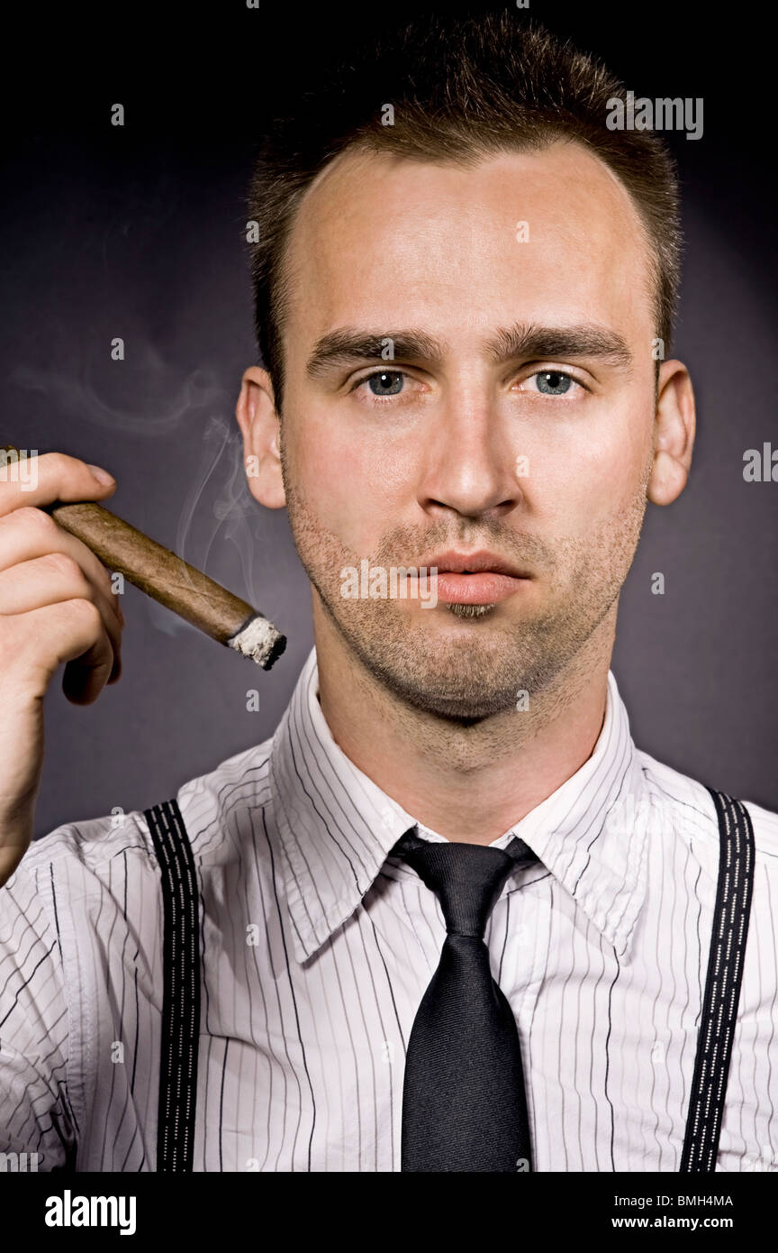 young handsome confident man smoking cigaro Stock Photo - Alamy