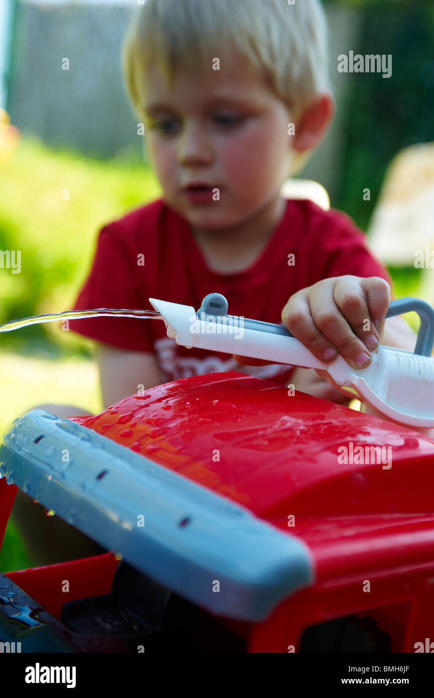 Boy With Toy Fire Engine on garden lawn Stock Photo - Alamy