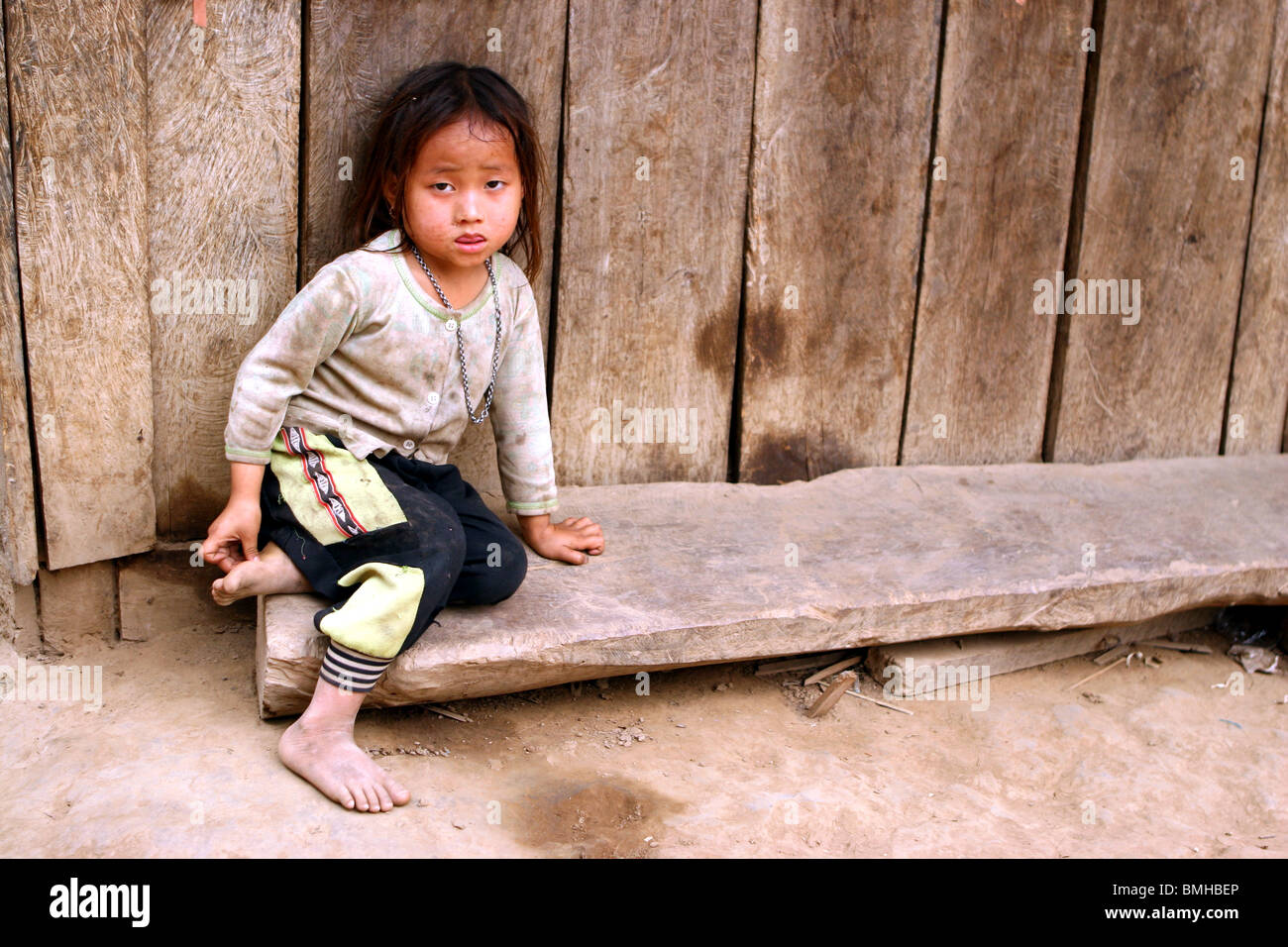 Hmong Child sitting outside a house in a small village between Pakbeng ...