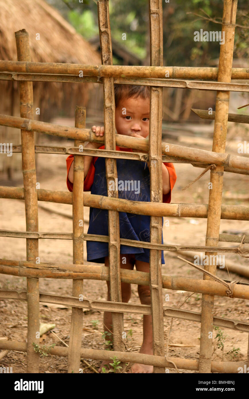 Hmong Child looking through a fence in a small village between Pakbeng ...