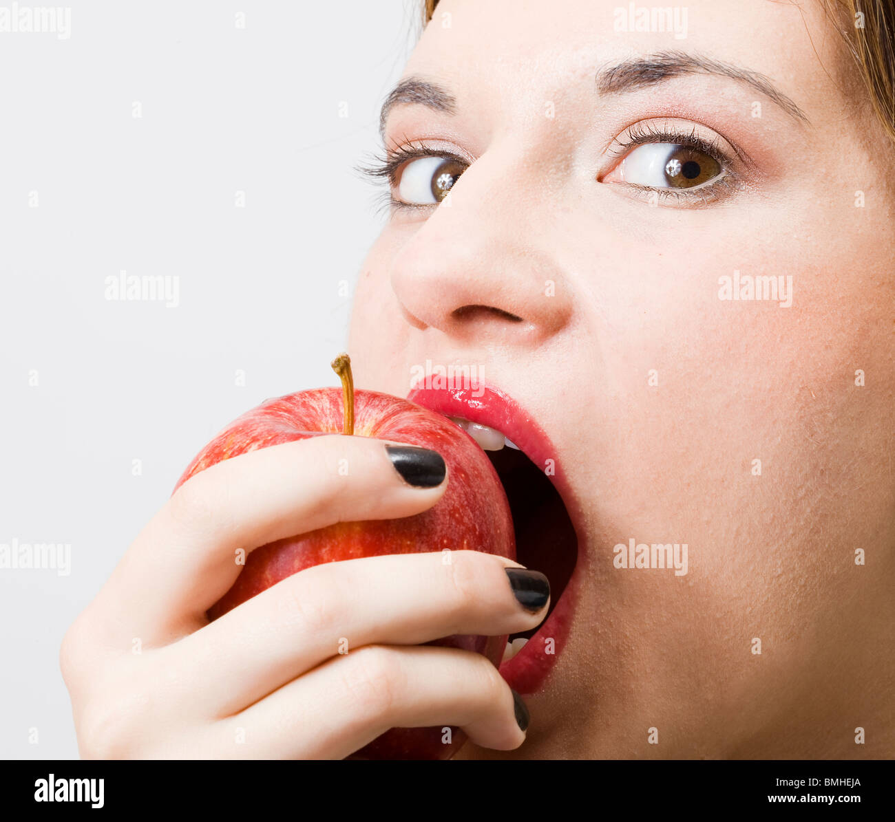 a young pretty girl eating a fresh healthy red apple Stock Photo - Alamy