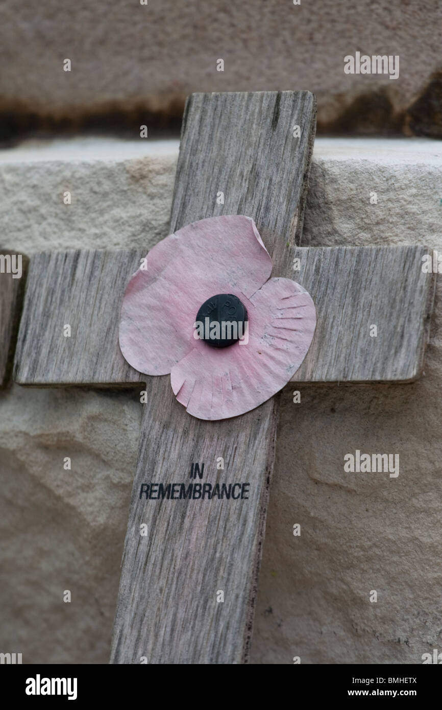 In rememberance cross next to a statue commerating the fallen soldiers ...