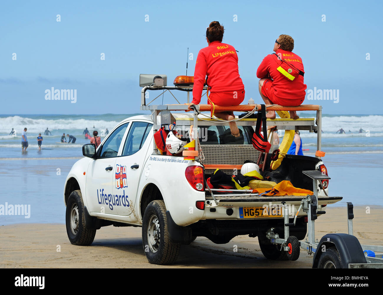 two lifeguards watching holidaymakers at perranporth beach, cornwall ...
