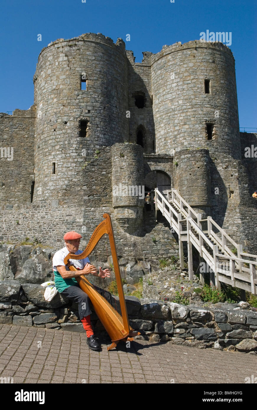 Harlech Castle, senior man, Welsh musician playing his Welsh Harp for ...