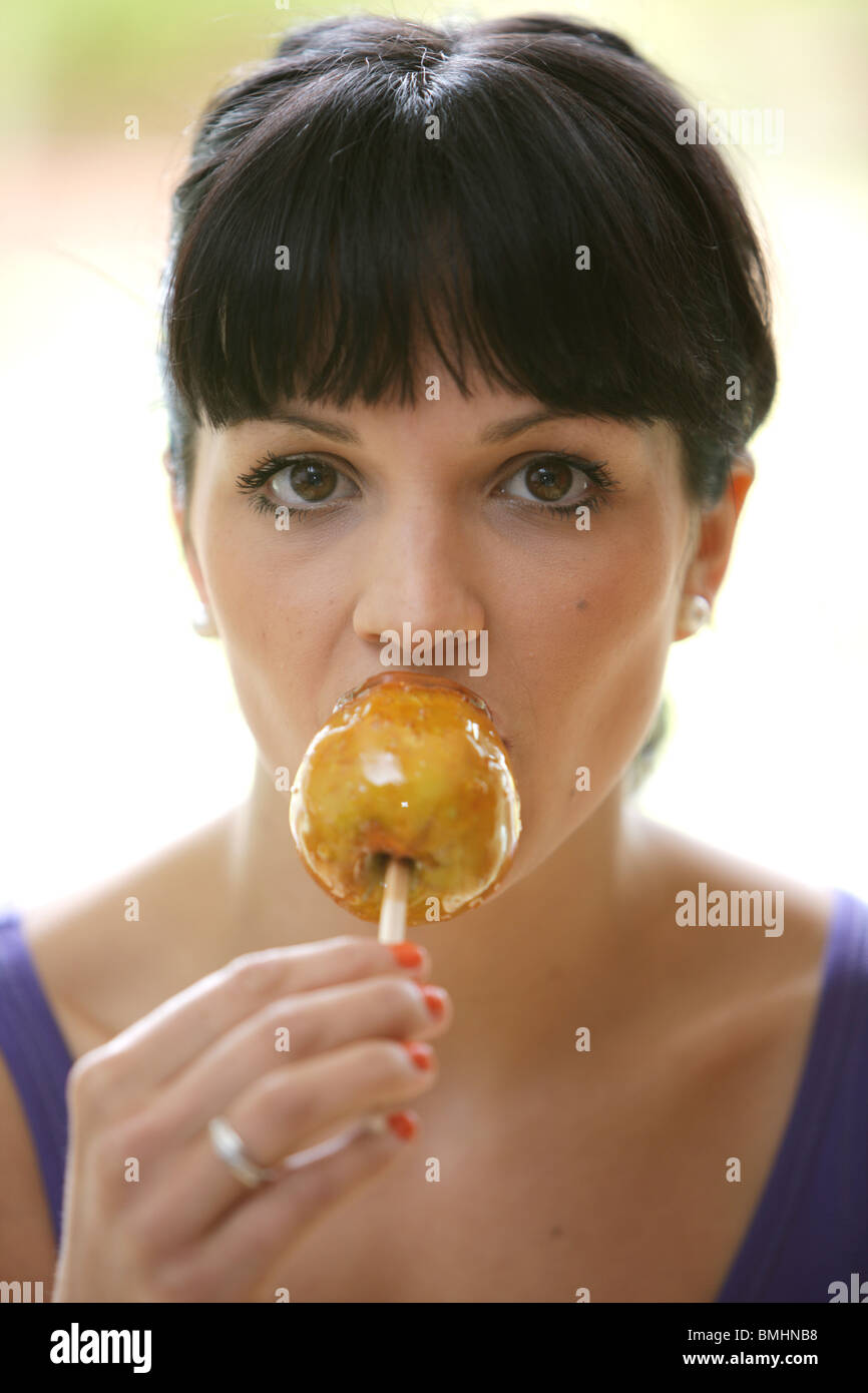 Young Woman Eating a Toffee Apple. Model Released Stock Photo - Alamy