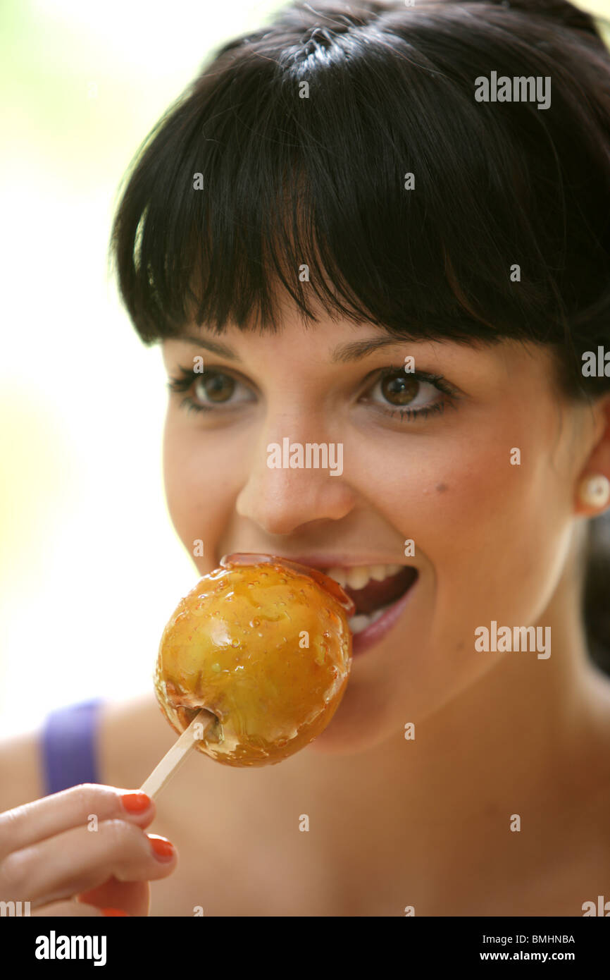Young Woman Eating a Toffee Apple. Model Released Stock Photo - Alamy