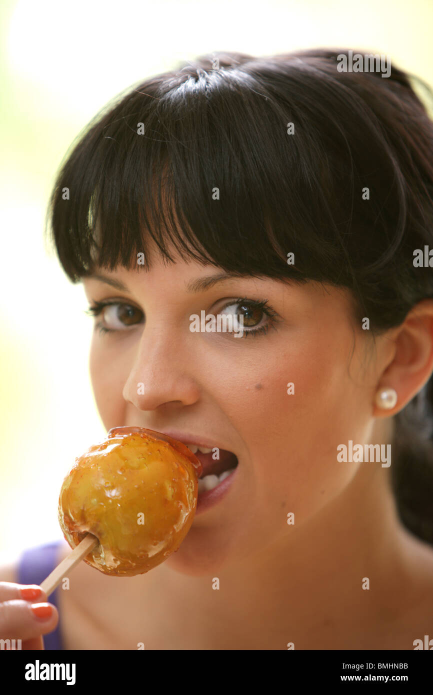 Young Woman Eating a Toffee Apple. Model Released Stock Photo - Alamy
