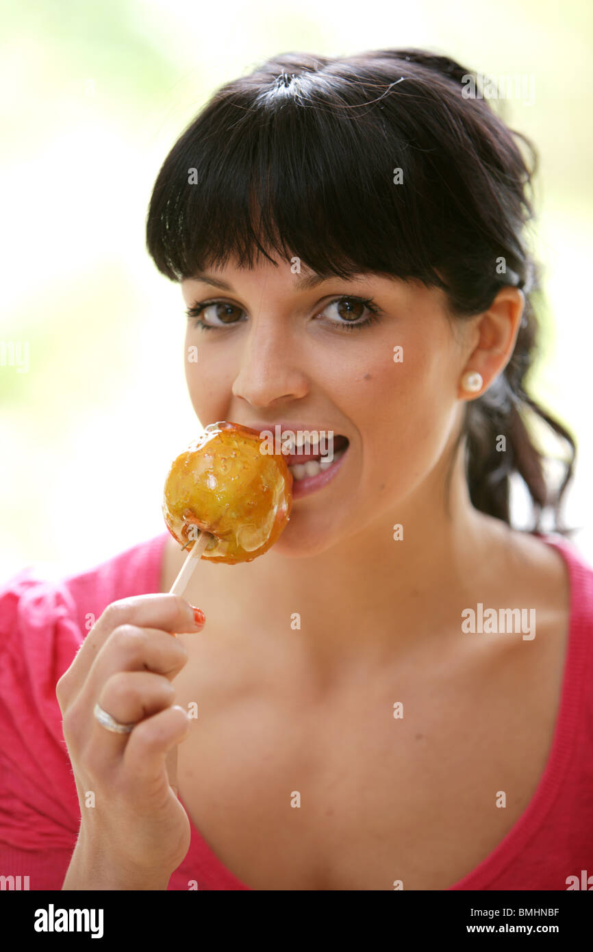 Young Woman Eating a Toffee Apple. Model Released Stock Photo - Alamy