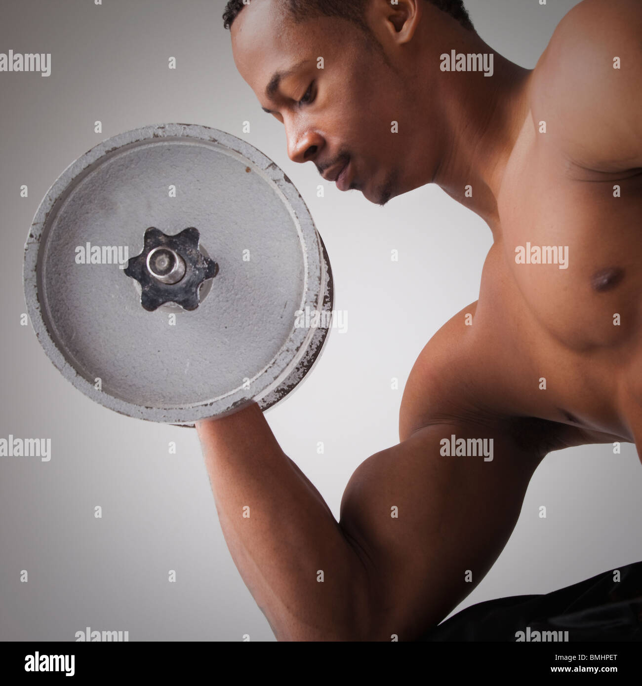 Muscular man lifting a dumbbell Stock Photo - Alamy