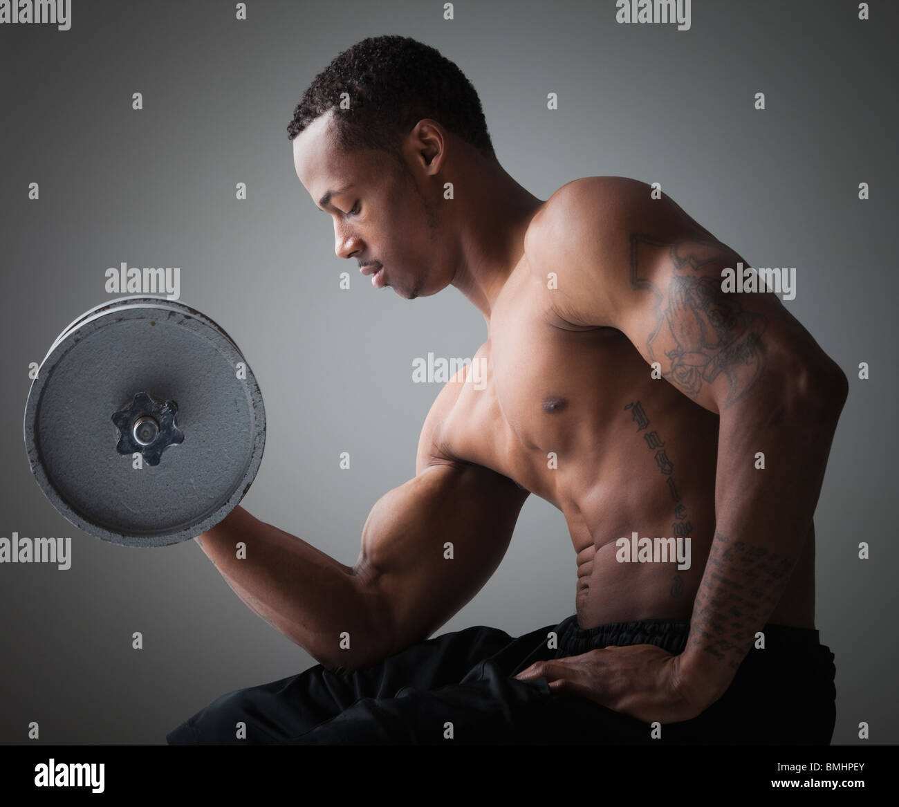 Muscular man lifting a dumbbell Stock Photo - Alamy
