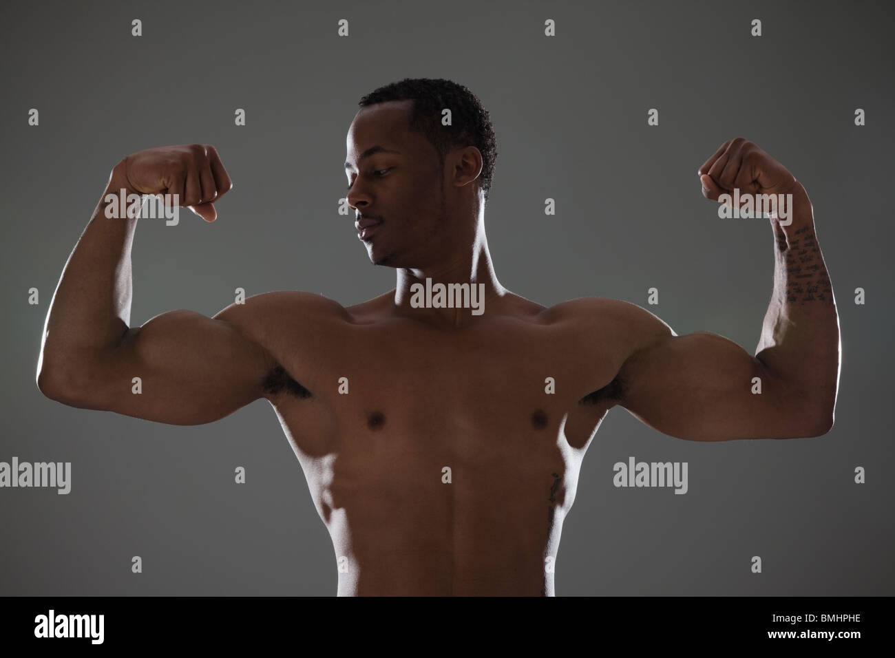 Physically fit man flexing his triceps Stock Photo - Alamy