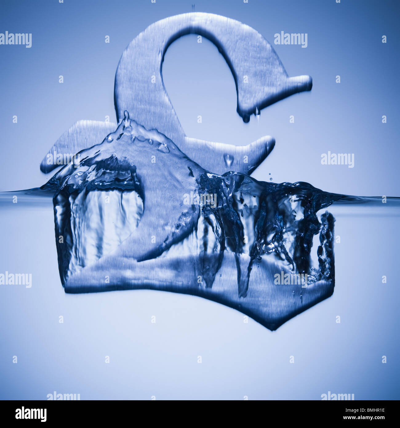 British pound symbol sinking in water Stock Photo - Alamy