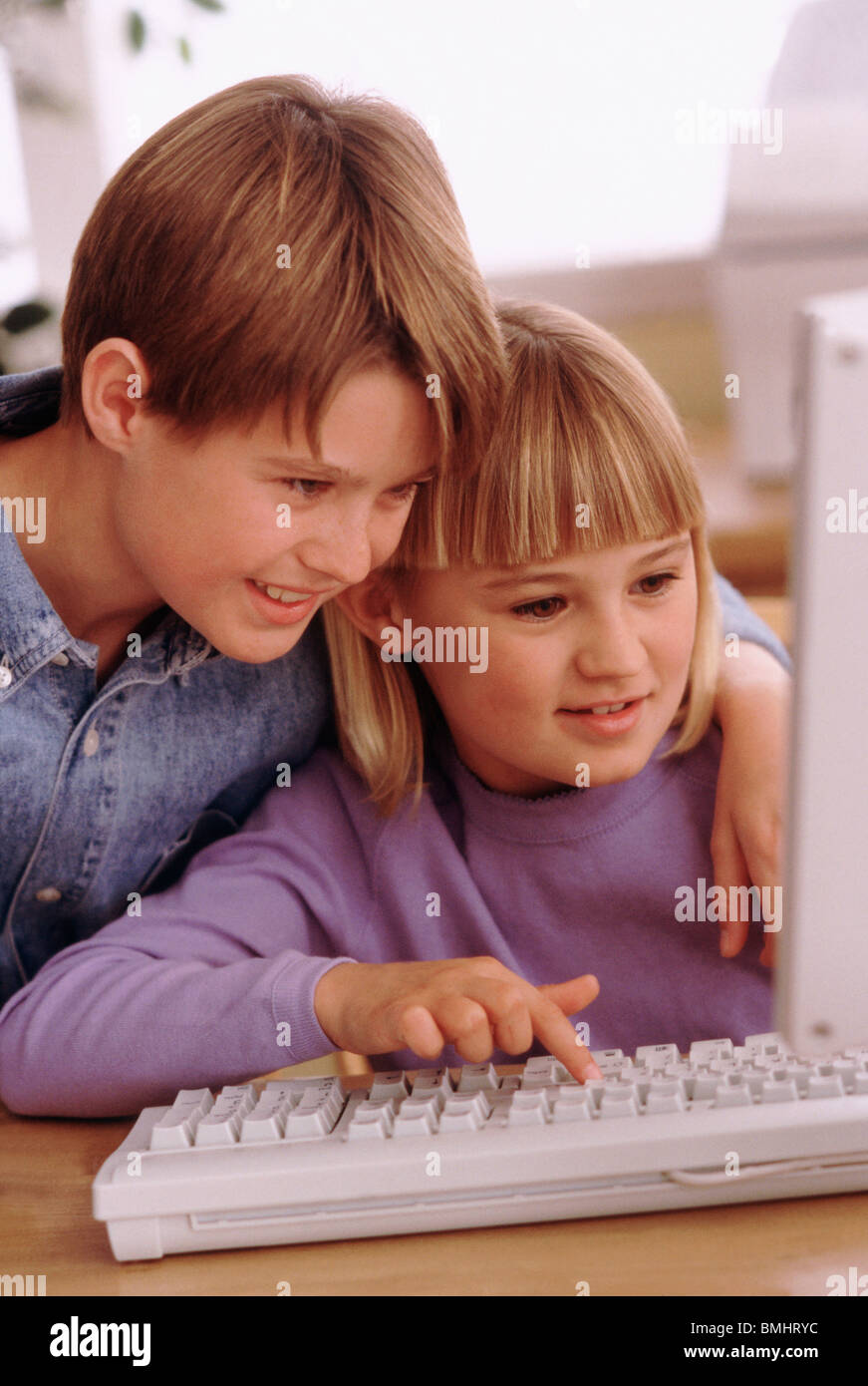 Siblings looking at computer together Stock Photo - Alamy