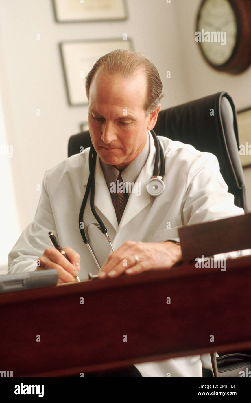 Doctor sitting desktop writing hi-res stock photography and images - Alamy