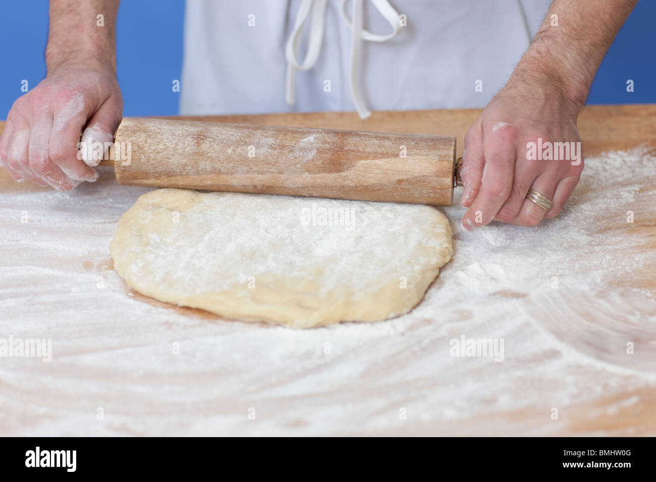 Man' hands rolling out bread dough Stock Photo - Alamy