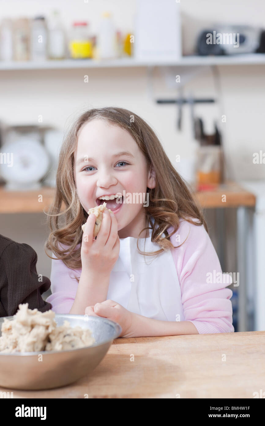 Young girl eating cookie batter Stock Photo - Alamy