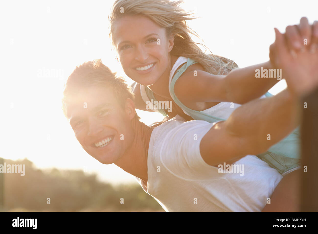 Man giving girlfriend a piggy back ride Stock Photo - Alamy