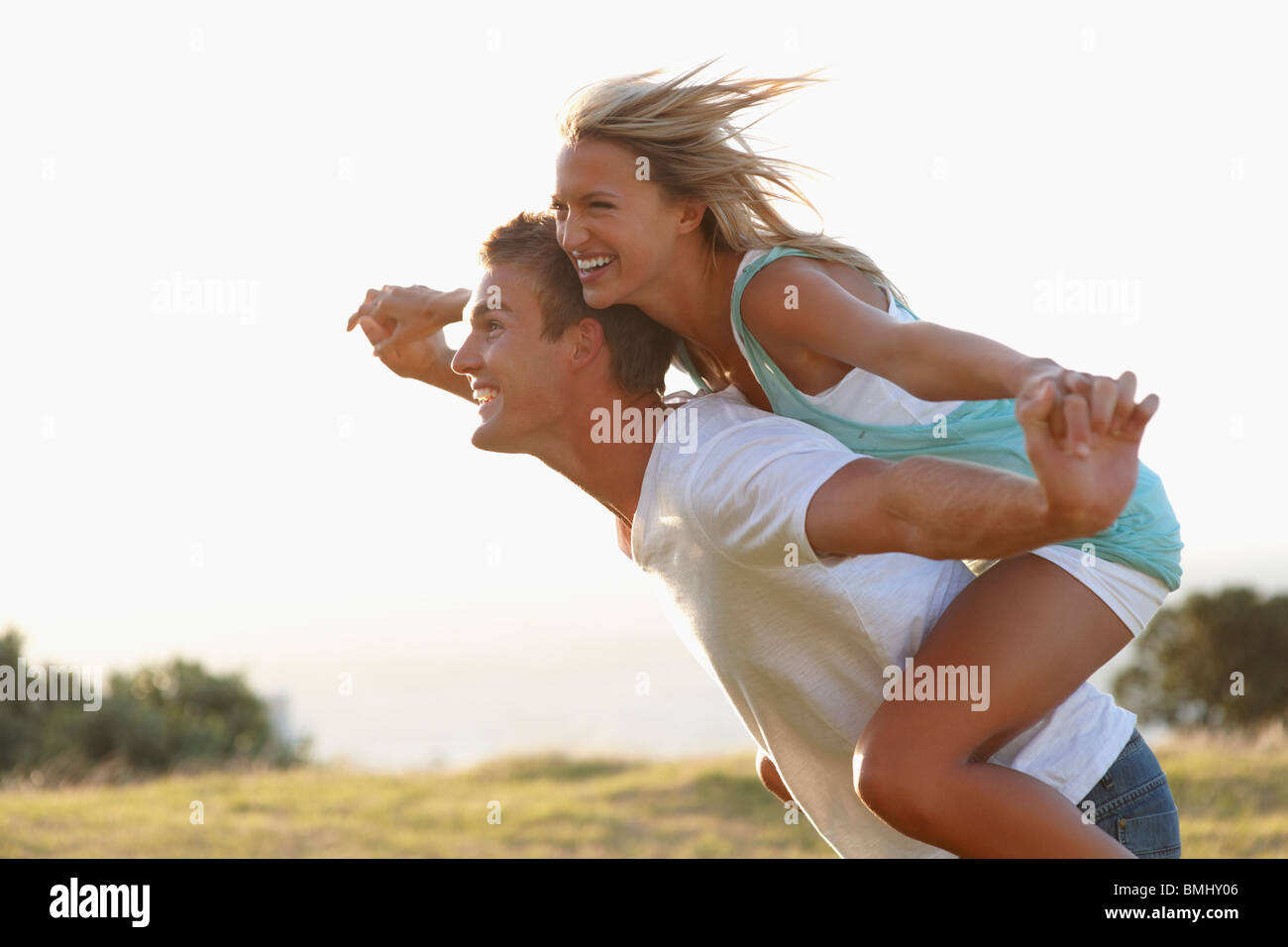 Man giving girlfriend a piggy back ride Stock Photo - Alamy