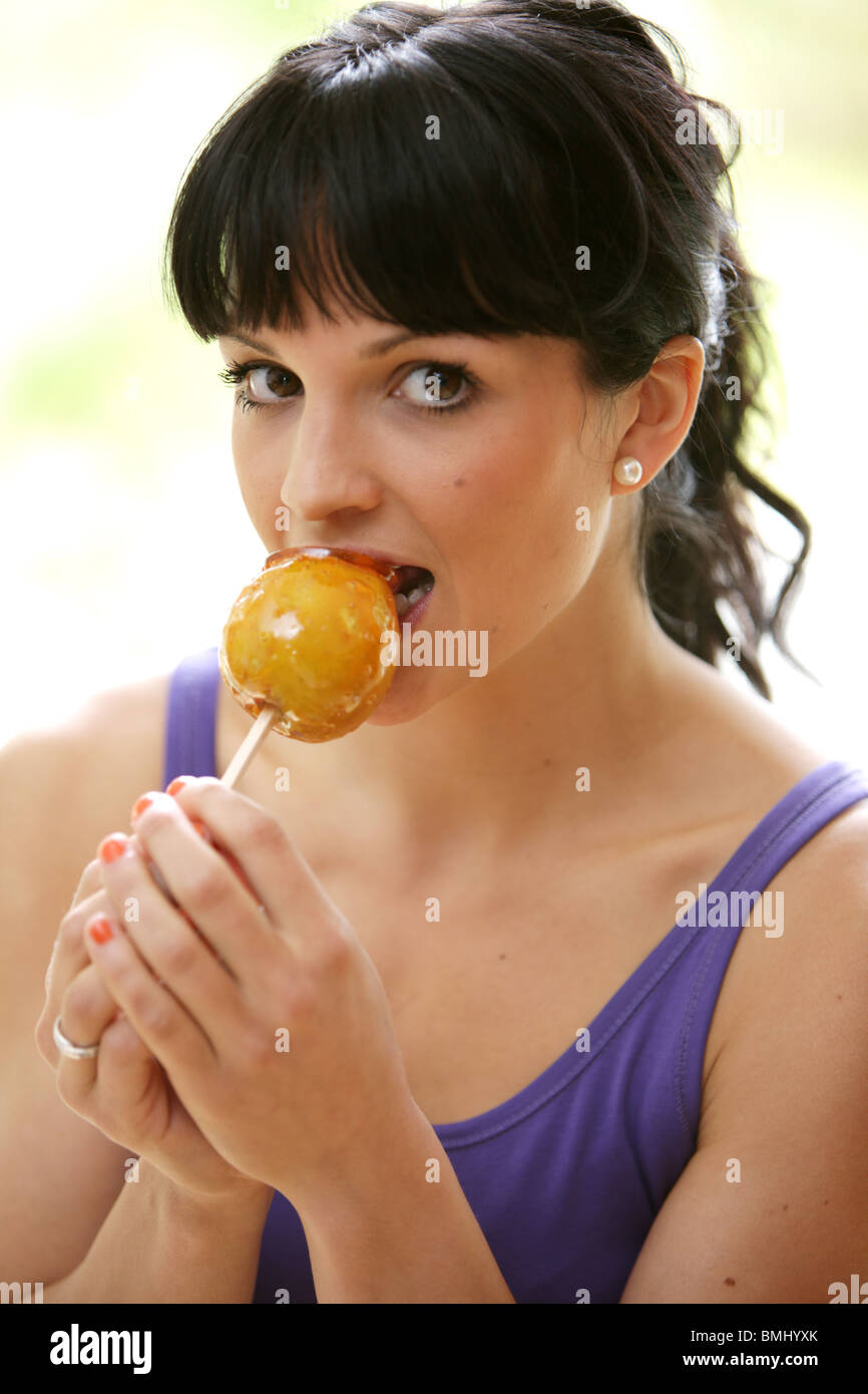 Young Woman Eating a Toffee Apple. Model Released Stock Photo - Alamy